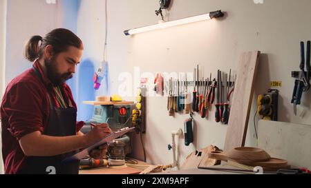 Craftsperson drawing blueprints on notepad in studio with BIPOC ...