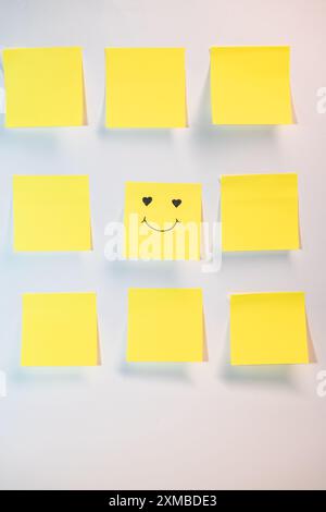 A yellow post it with a smiley face on it. There are nine other yellow ...