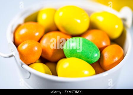 Colorful round chocolate candies in red, yellow, blue, and green fill a ...