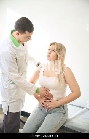 Sick and stomachache man being examined by the doctor. Doctor pressing ...