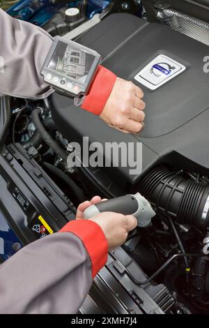 mecanic using a digital endoscope to check a car engine Stock Photo - Alamy