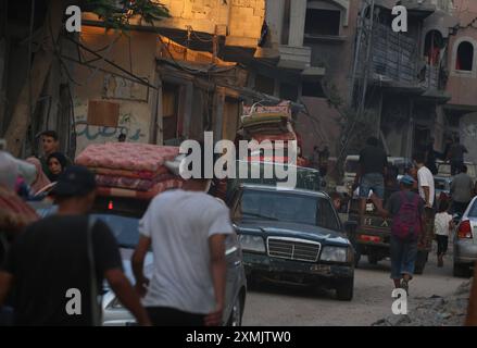 Palestinians carrying their personal belongings flee the al-Bureij ...