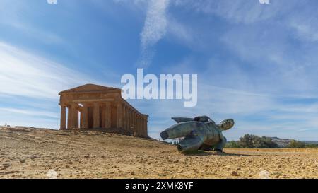 Statue of fallen Icarus in bronze in front of the 2,400 year old Temple ...