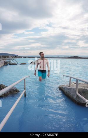 Milky blue waters of the Blue Lagoon in Iceland contrast with black ...