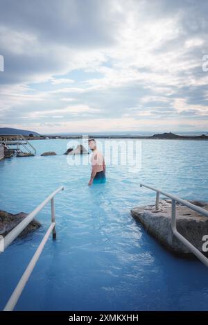 Man enjoying blue lagoon geothermal waters. Iceland attraction landmark ...