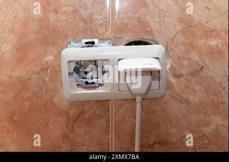 Broken socket on ceramic tile wall. Broken outlet. Concept of risk of ...