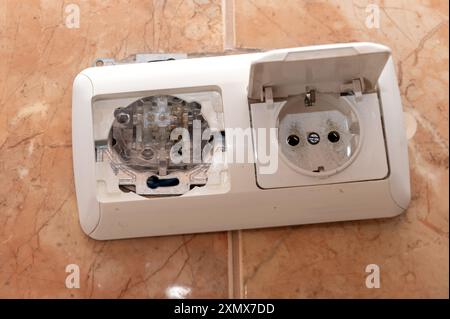 Broken socket on ceramic tile wall. Broken outlet. Concept of risk of ...