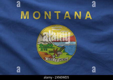Montana US state flag depicted on folded wavy fabric of old cloth close ...