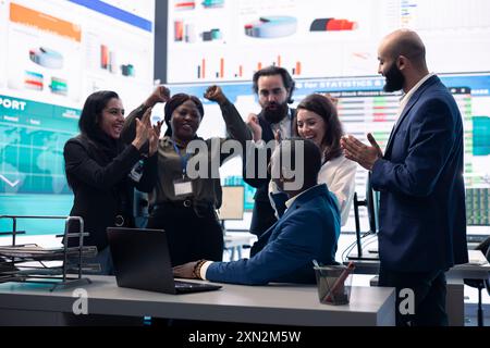 Business administrator celebrating expansion progress with his team ...