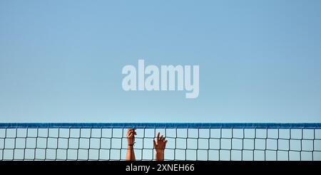 a player's hands reach over the net in a crucial block attempt. This ...