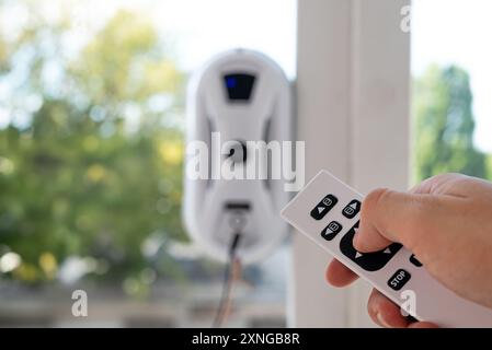 Remote control of a robotic window washer that washes glass from dirt ...