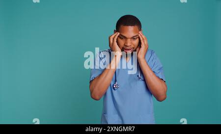 Fatigued nurse suffering from migraine pain after tiresome day at work ...