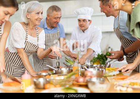 Young guy cook teaches to cook group of people Stock Photo - Alamy