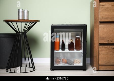 Mini refrigerator with different drinks and snacks indoors Stock Photo ...