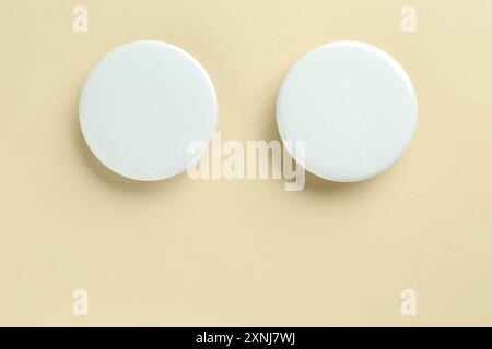 White button badges on beige background, flat lay. Mockup for design ...