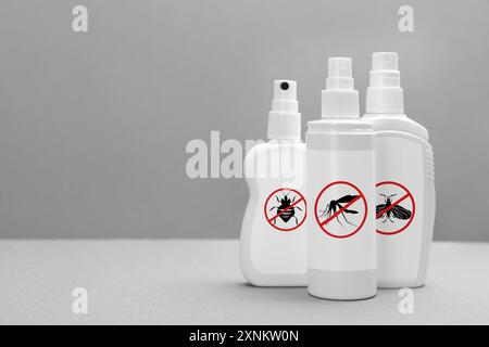 Different insect repellents in spray bottles on grey background Stock ...