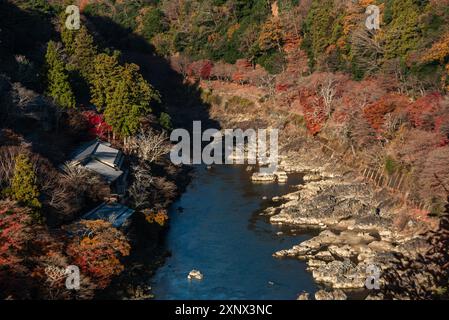 Autumnal forests with deep blue Katsura Riverwith temple roofs on the ...
