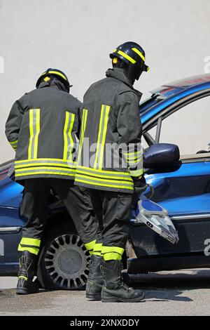firefighter with his team while shearing the car with a powerful ...