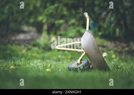 Tipped child hand barrow in green garden Stock Photo - Alamy