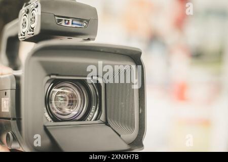 Male cameraman is holding a professional video camcorder, blurry ...