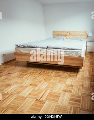 Large comfortable stone pine bed in bedroom Stock Photo - Alamy