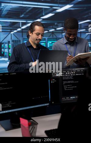 Software developer checking for signs of imminent failure in data center equipment. IT ...