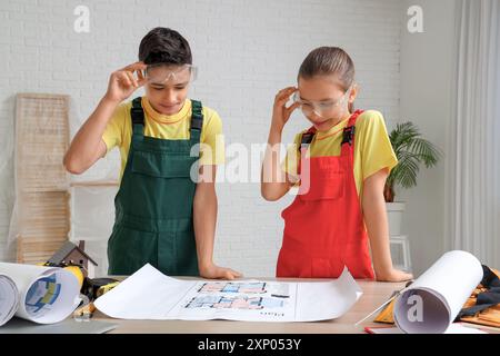 Little architects working with house plan at table in room Stock Photo ...