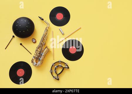Different musical instruments and vinyl disks on yellow background ...