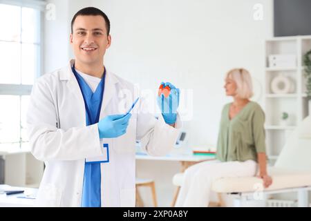 Male endocrinologist with thyroid gland model in clinic Stock Photo - Alamy