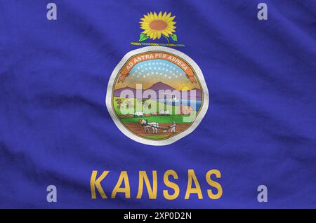 Kansas US state flag depicted on folded wavy fabric of old cloth close ...