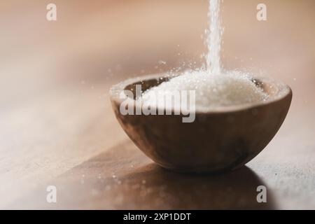 White sugar falling in wood bowl on table, shallow focus Stock Photo ...