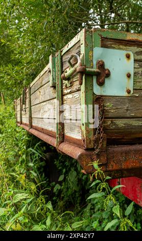 Old farm trailer in the bushes. Wooden sides. Museum object. Abandoned ...