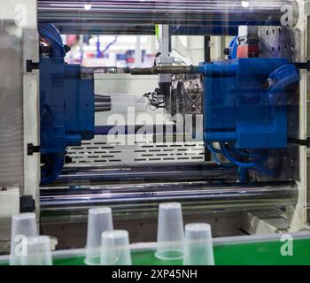 Plastic cups from plastic injection molding press machine. Industrial ...