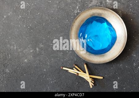 Chafing fuel gel poured into metal dish with matchsticks, blue chafer ...