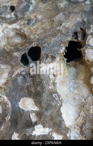 Patterns and textures of a rock wall with holes Stock Photo - Alamy