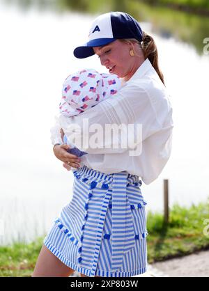 Meredith Scudder, wife of Scottie Scheffler (left), cradles their son ...