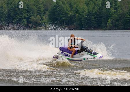 Tomahawk, Wisconsin, USA - July, 30, 2024: Young lady driving a jet ski ...