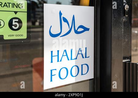 Halal Food sign written in Arabic and English displayed in the window ...
