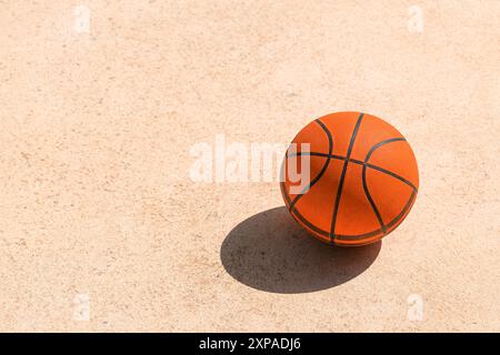 Used basketball ball on concrete surface of outdoor court in summer ...