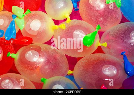 Close up of a pink outdoor pastic pool fillled with multicolored water ...