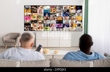 Two Men Watching Television With Multiple Images Displayed on Screen ...