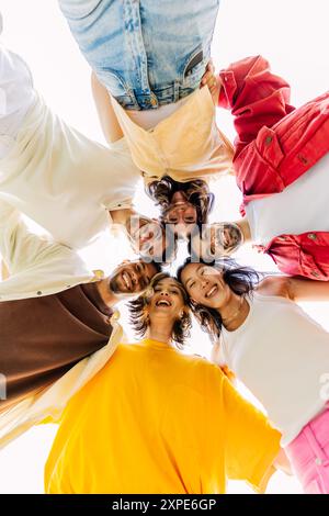 Low angle of a group of young teenagers holding cell phones. Surprised ...