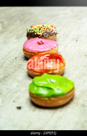 Four donuts of different flavors on a black circular tray Stock Photo ...