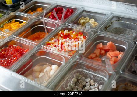 A view of several containers full of toppings in a frozen yogurt or ice ...