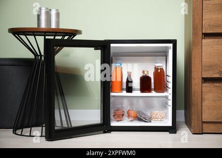 Mini refrigerator with different drinks and snacks indoors Stock Photo ...