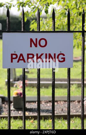 No parking sign attached to wrought iron railings outside cemetery in ...