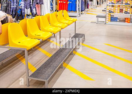 yellow stylish seats for putting on shoes in the shoe department of the ...