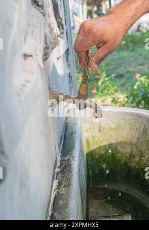 A hand opening a tap in a park Stock Photo - Alamy