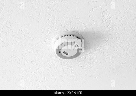 White ceiling mounted fire safety device smoke detector Stock Photo - Alamy