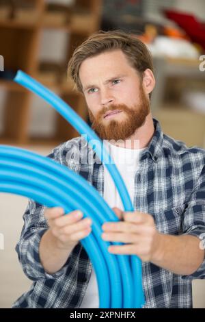 Young plumber holding pvc pipe Stock Photo - Alamy